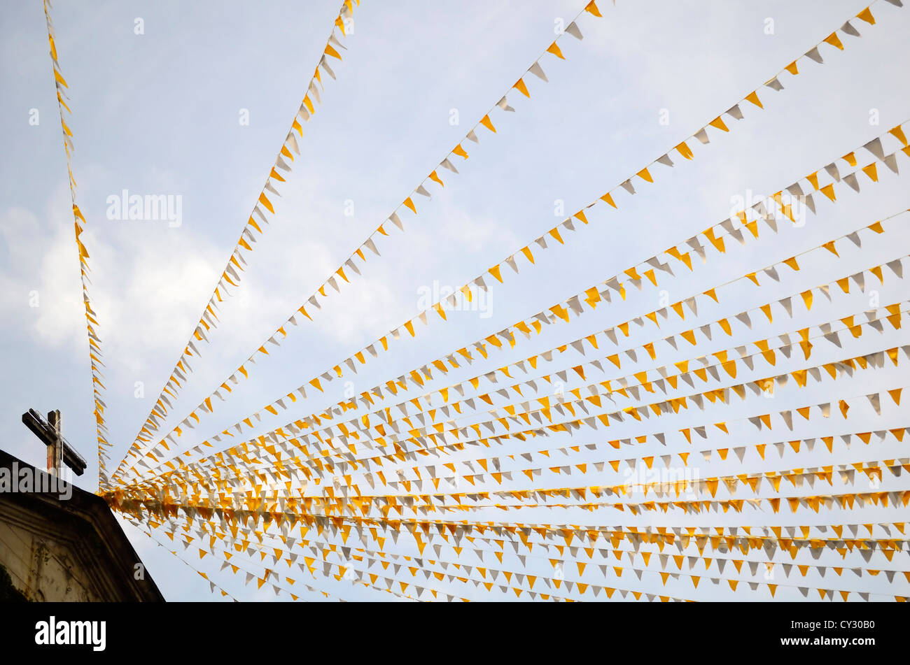 Crucifix on top of a Catholic Church with white and yellow flaglets ...