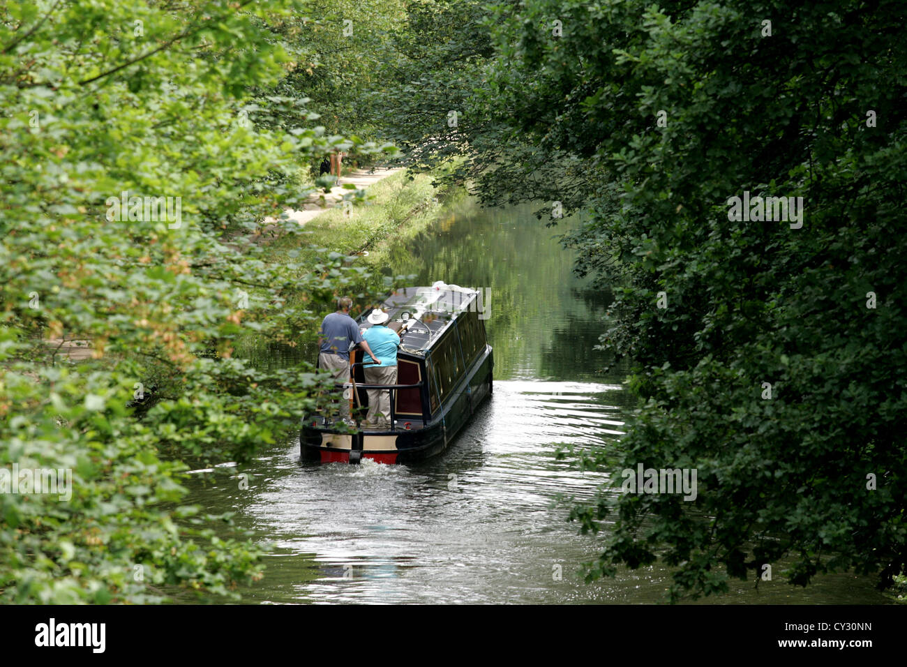 A canal longboat chugs it's way along the canal near the university of ...