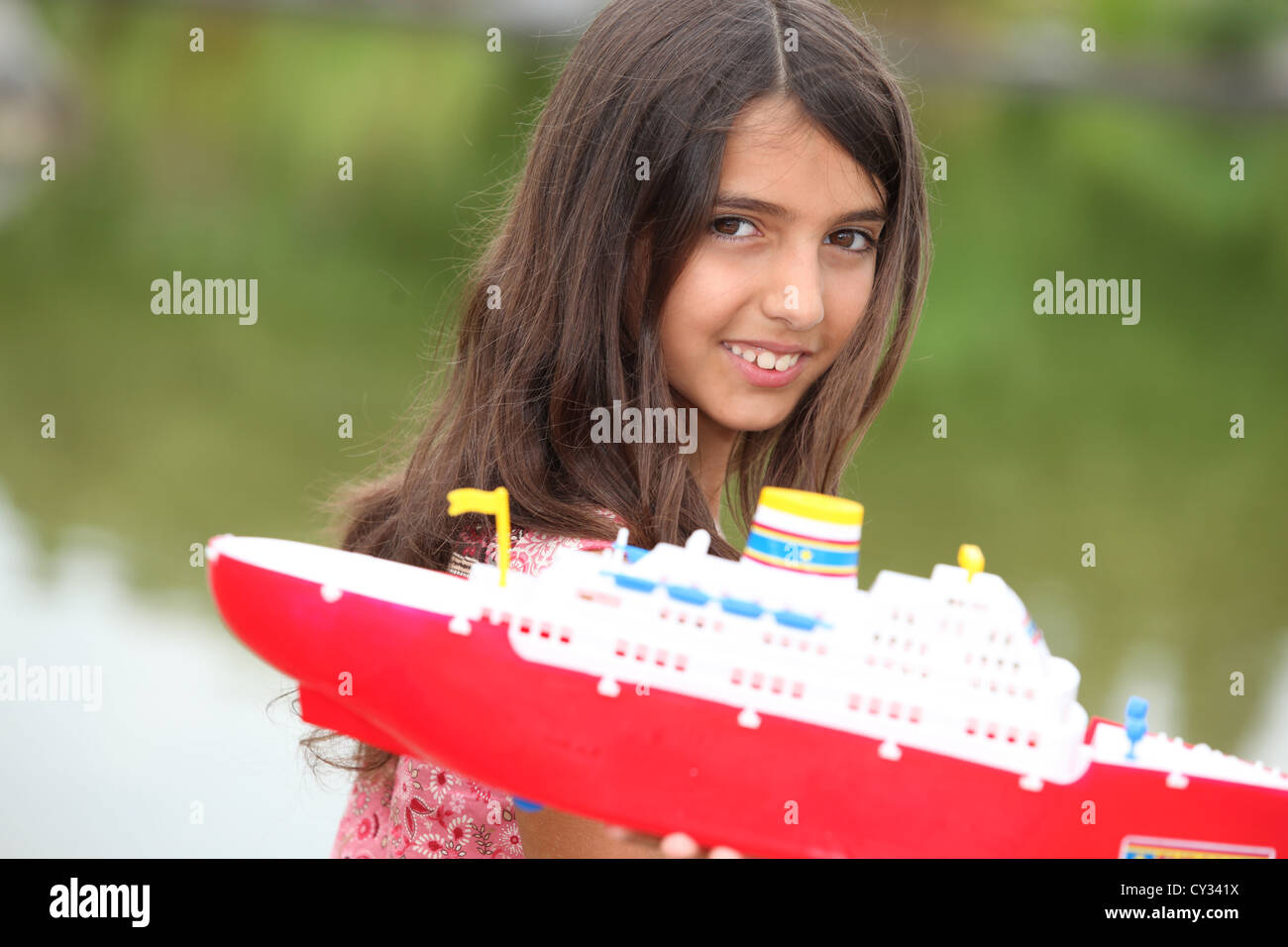 Young girl with a toy boat at a lake Stock Photo - Alamy