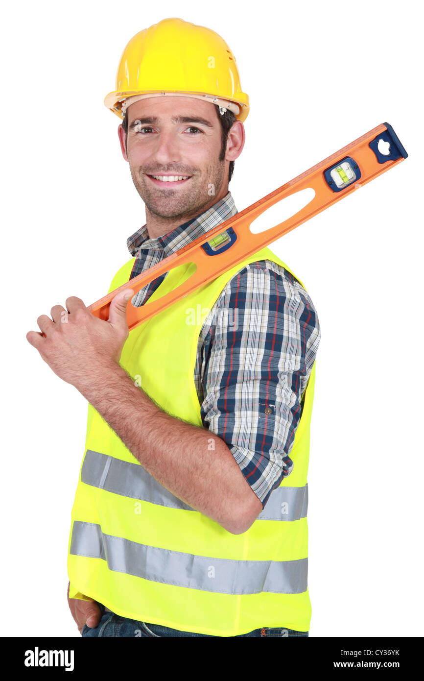 Happy worker resting spirit-level on shoulder Stock Photo - Alamy