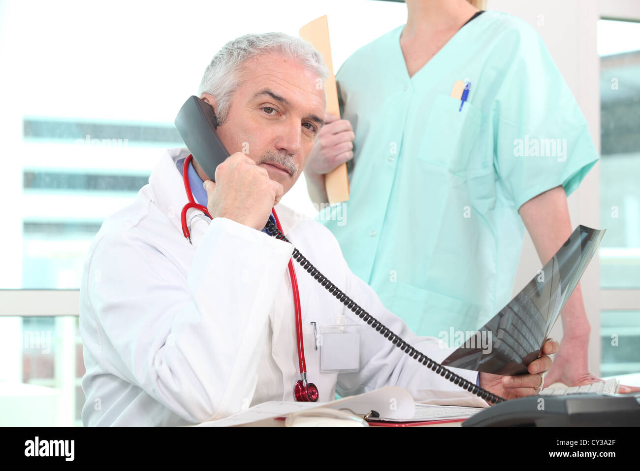 Doctor making a telephone call about some x-rays Stock Photo - Alamy