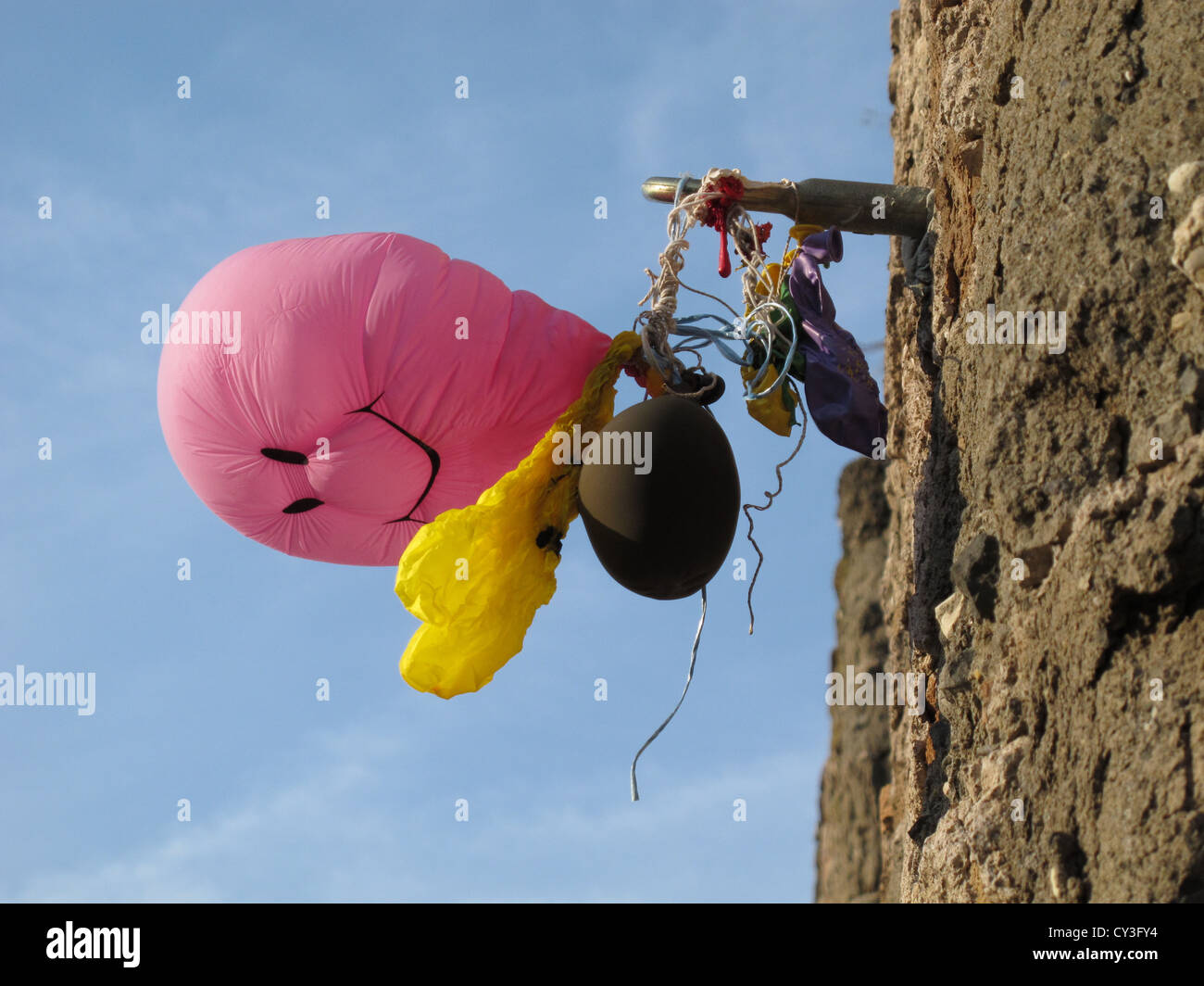 bunch of deflated balloons hanging from wall outdoors Stock Photo - Alamy