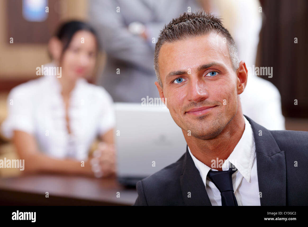 Handsome executive businessman with his team working behind Stock Photo ...