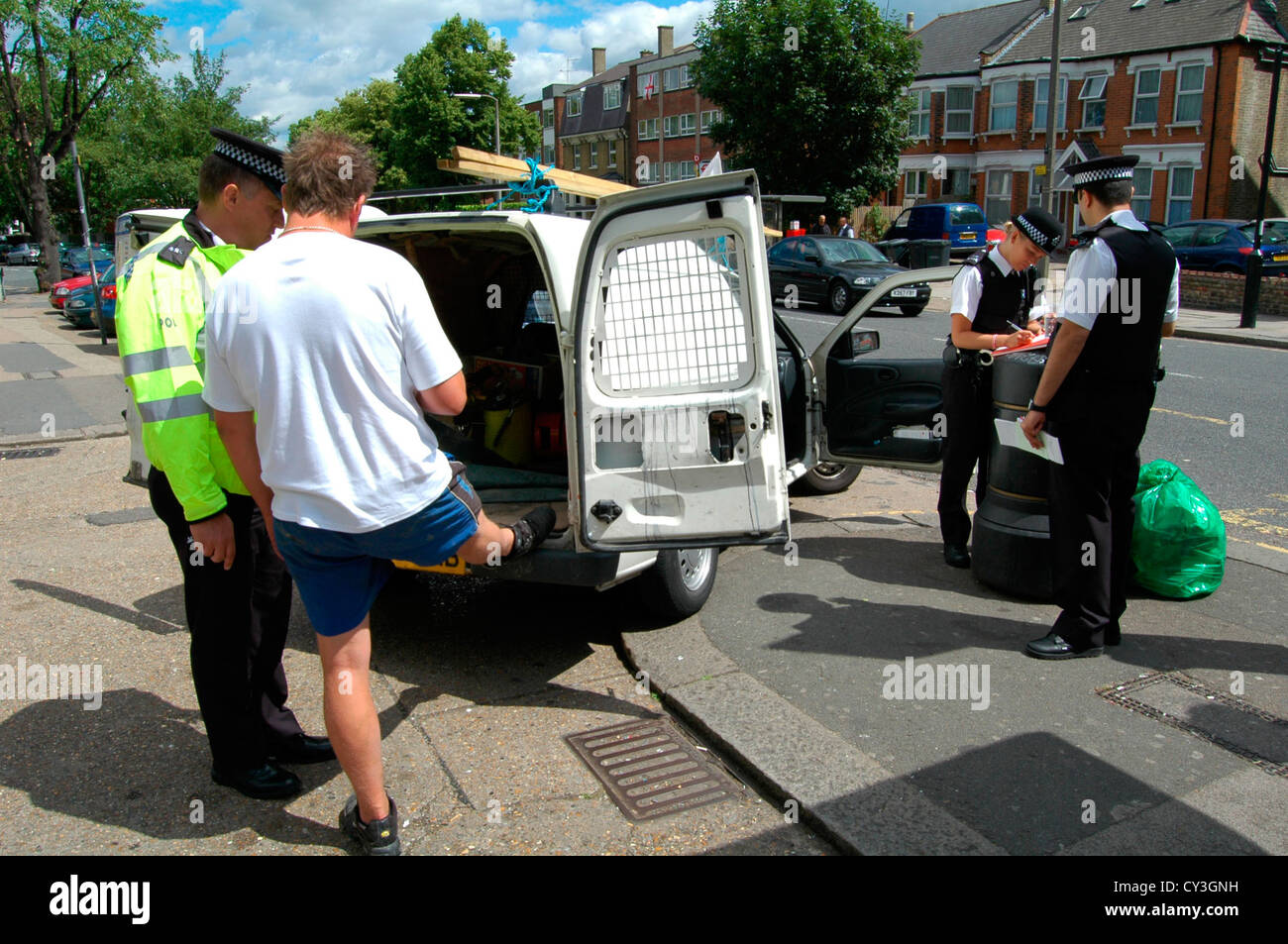 Police officers check a van and the details of a motorist after a stop ...