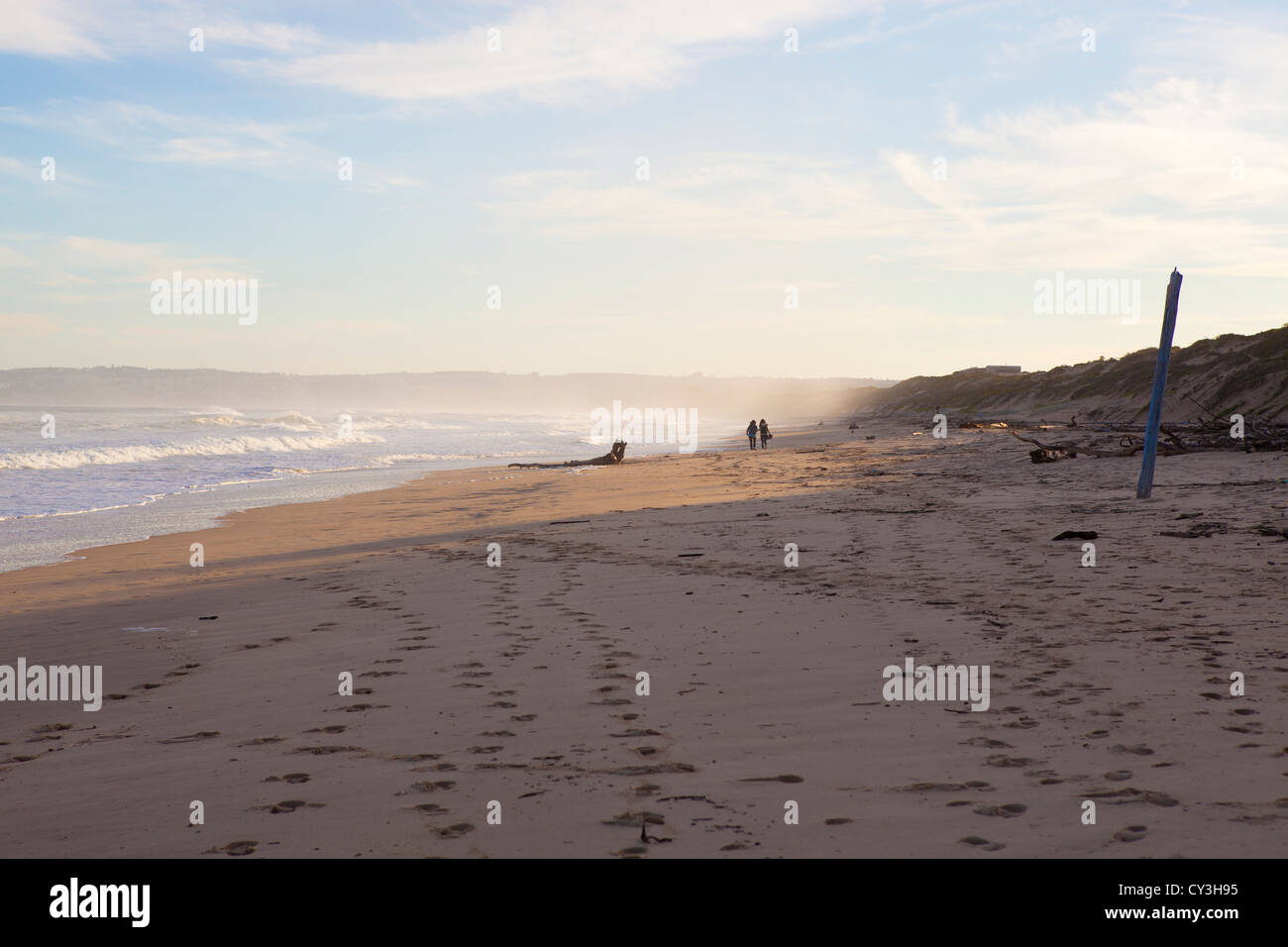 Two people walking along a beach Stock Photo - Alamy