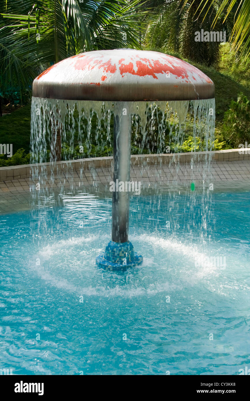 Circle of dripping water from umbrella in a recreation swimming pool ...