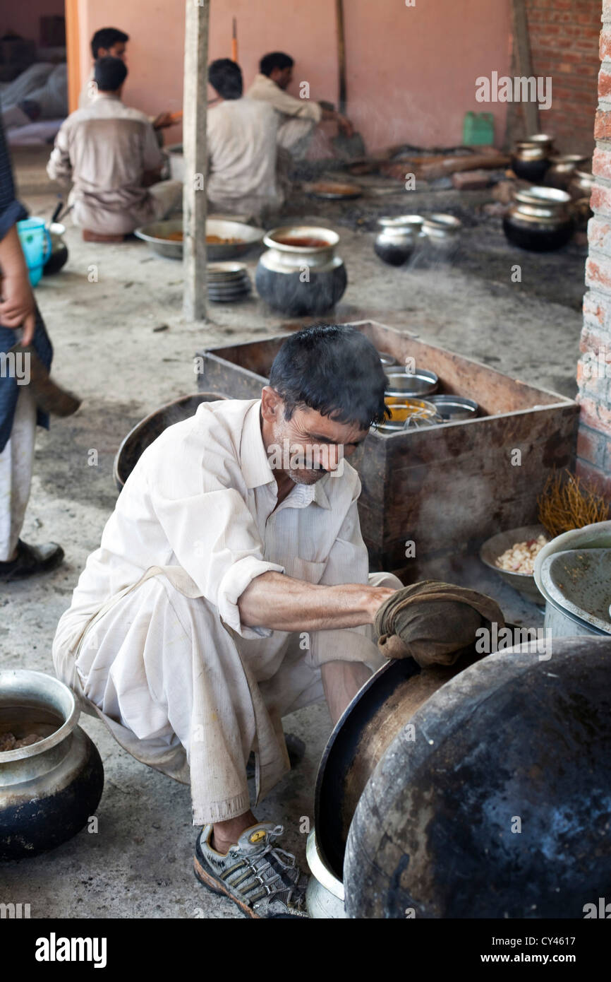A Waza or cooks in the Wazwan tradition empties a pot of food in ...