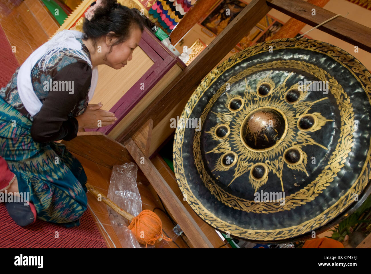 A gong ringer prays during a prayer ceremony in a temple in the Pha ...