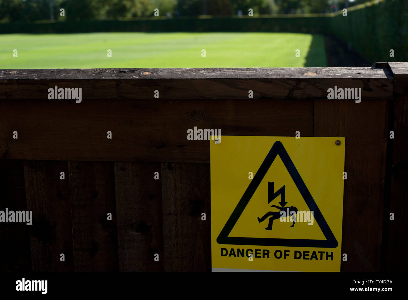 Sign on a wooden gate warning for danger of death upon entry to a green ...