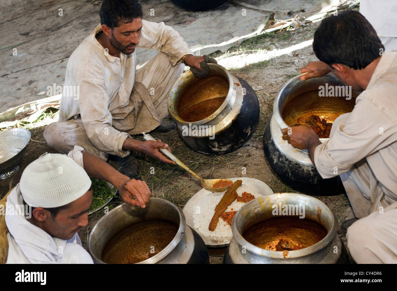 Wazas, traditional Kashmiri cooks, serve Wazwan onto a Trami (plate) at ...