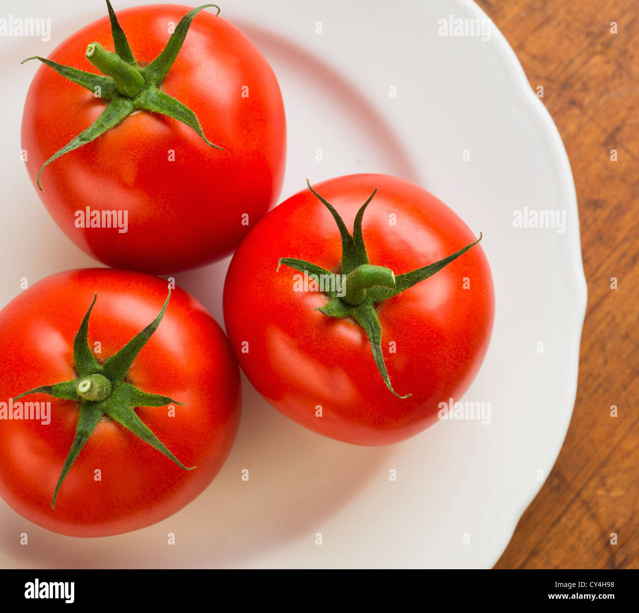 Tomatoes on plate, studio shot Stock Photo - Alamy