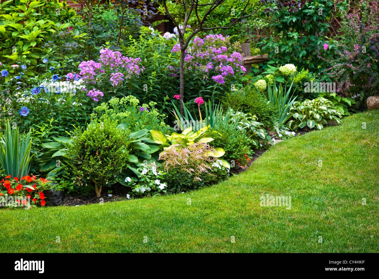 Lush landscaped garden with flowerbed and colorful plants Stock Photo ...