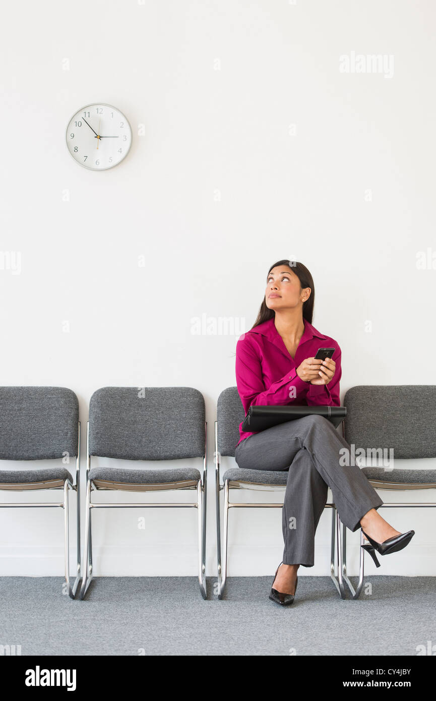 USA, New Jersey, Jersey City, Woman sitting in waiting room and text ...