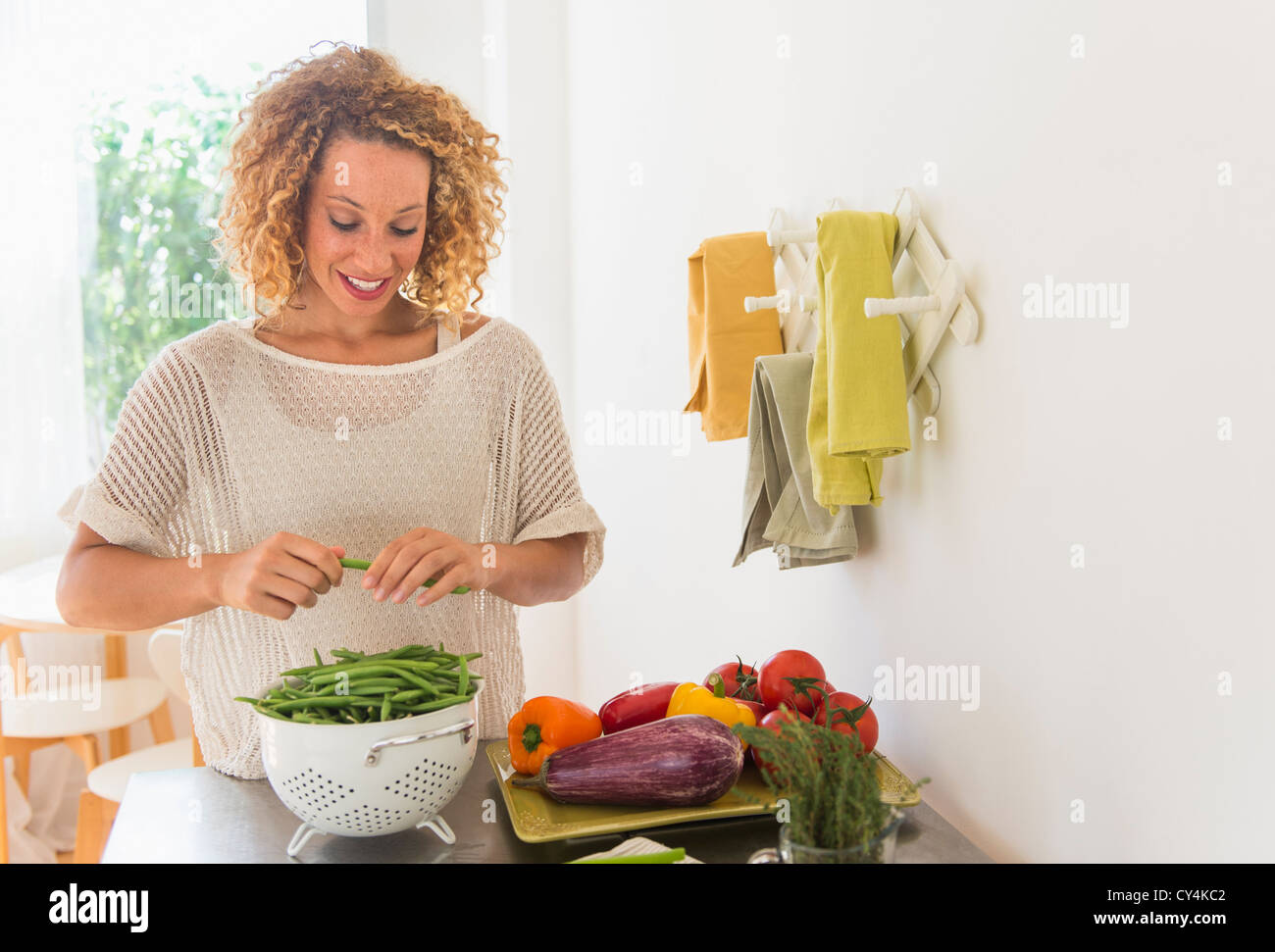 USA, New Jersey, Jersey City, Young woman preparing food in kitchen ...