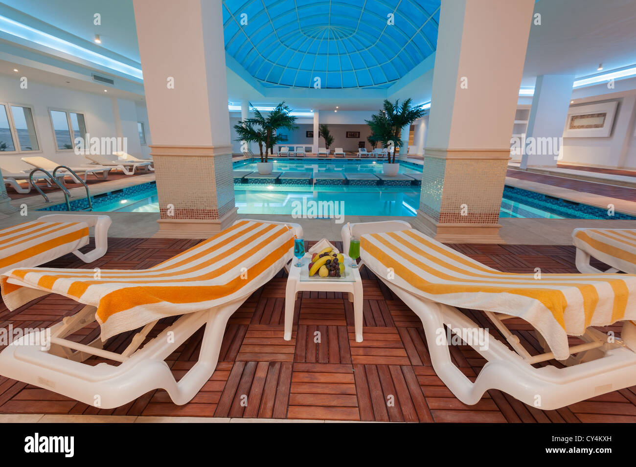 Large indoor sky pool at a luxury hotel with sunbeds Stock Photo - Alamy