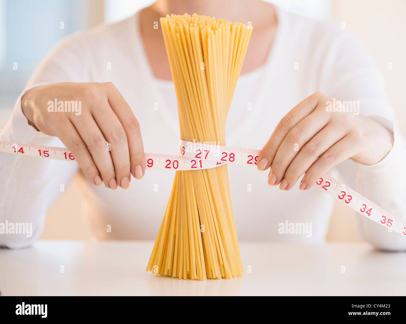 USA, New Jersey, Jersey City, Close up of woman's hands measuring pasta ...