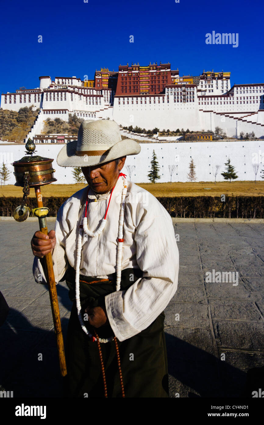 Pilgrim with prayer wheel by Potala Palace. Lhasa, Tibet Stock Photo ...