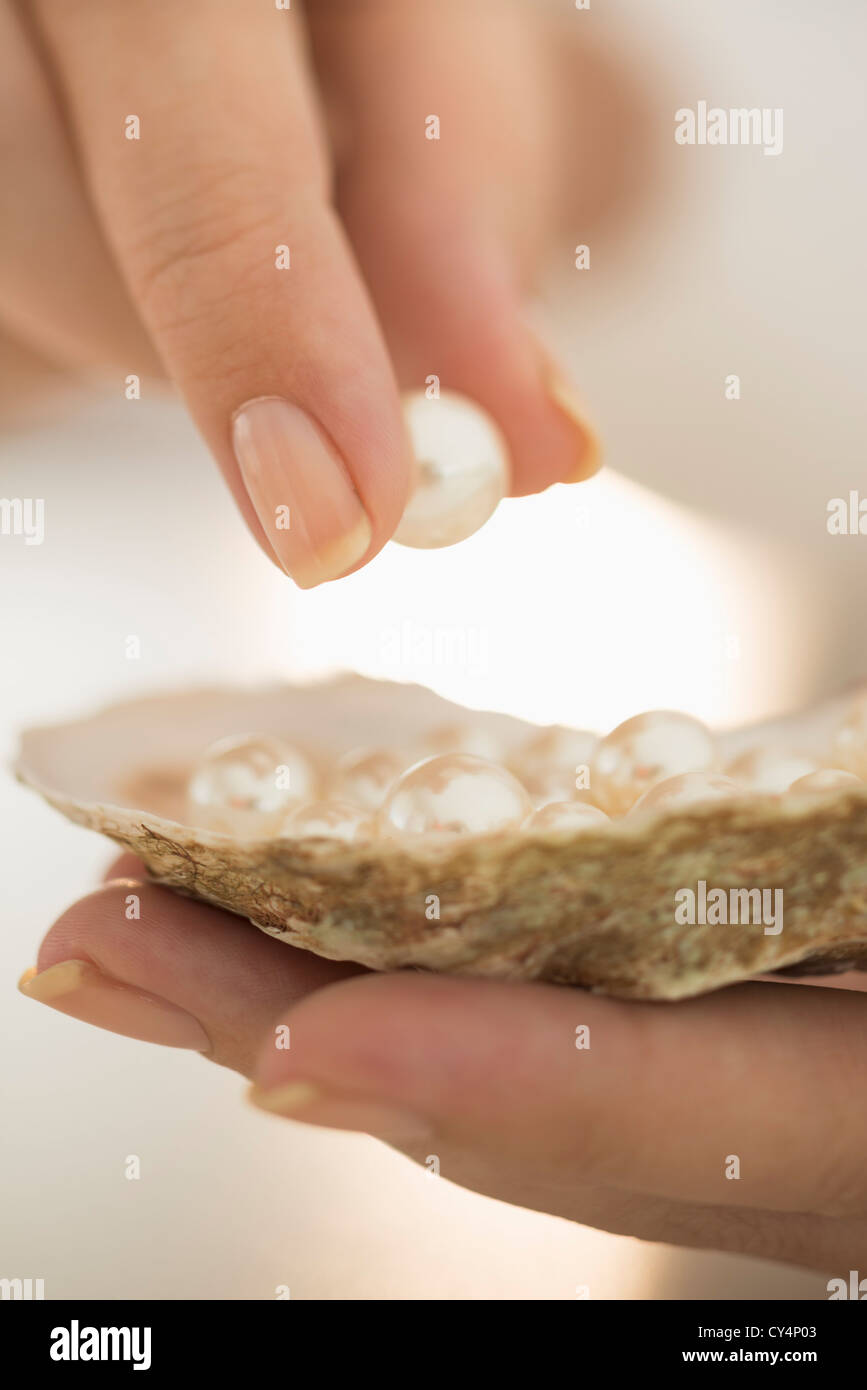 USA, New Jersey, Jersey City, Woman holding shell and pearl Stock Photo ...