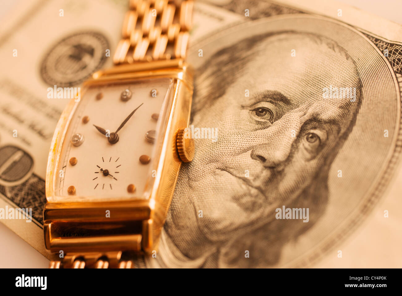 Studio shot of banknote and gold watch Stock Photo - Alamy