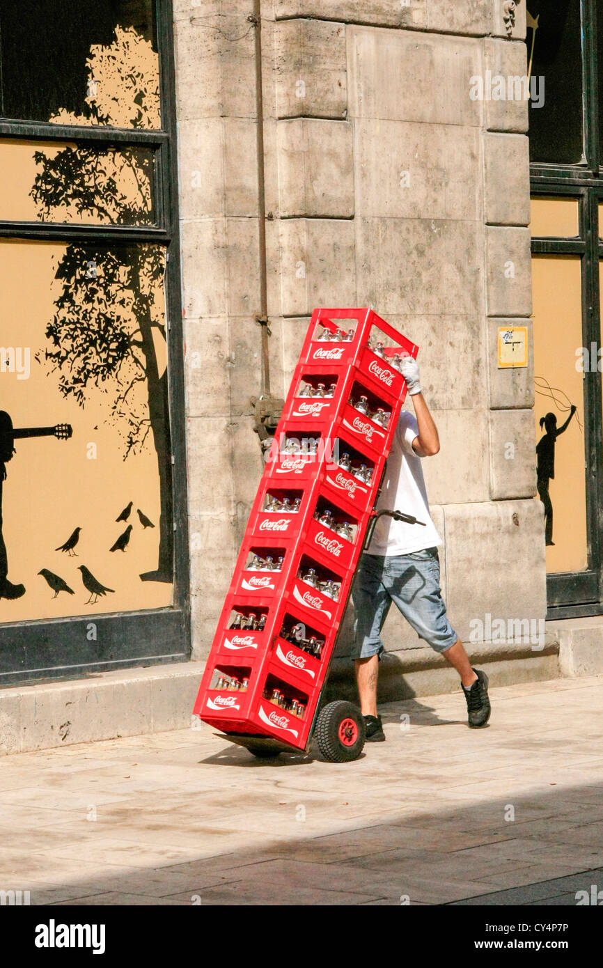 Coke delivery man wheels crates of the fizzy drink along the streets of ...