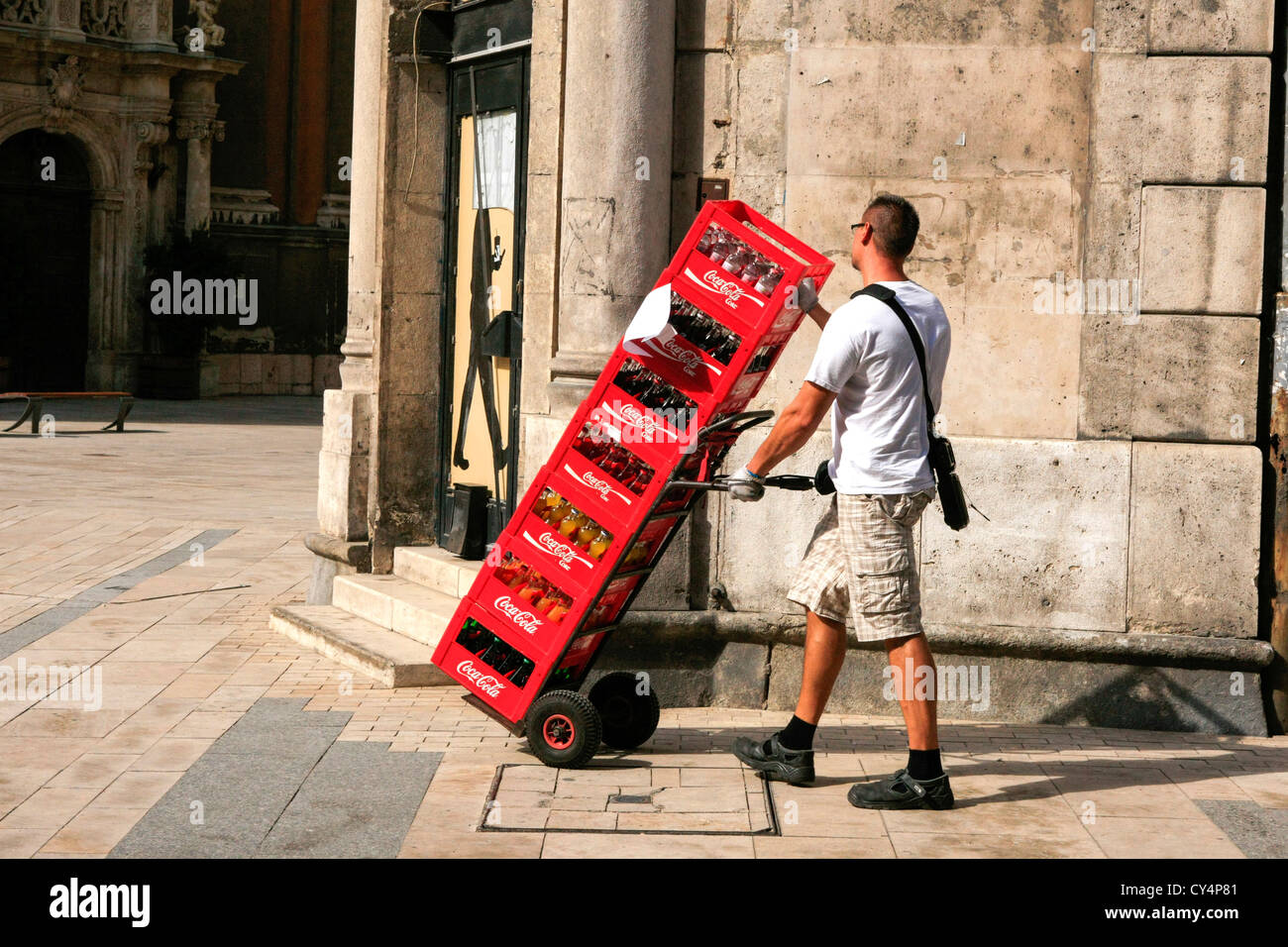 Coke delivery man wheels crates of the fizzy drink along the streets of ...