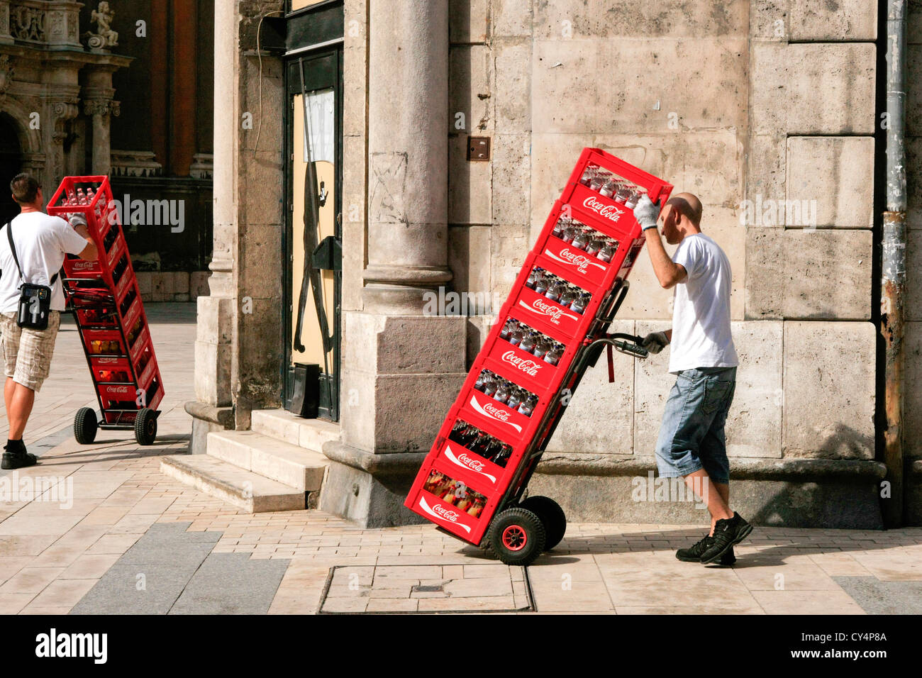 Coke delivery men wheels crates of the fizzy drink along the streets of ...