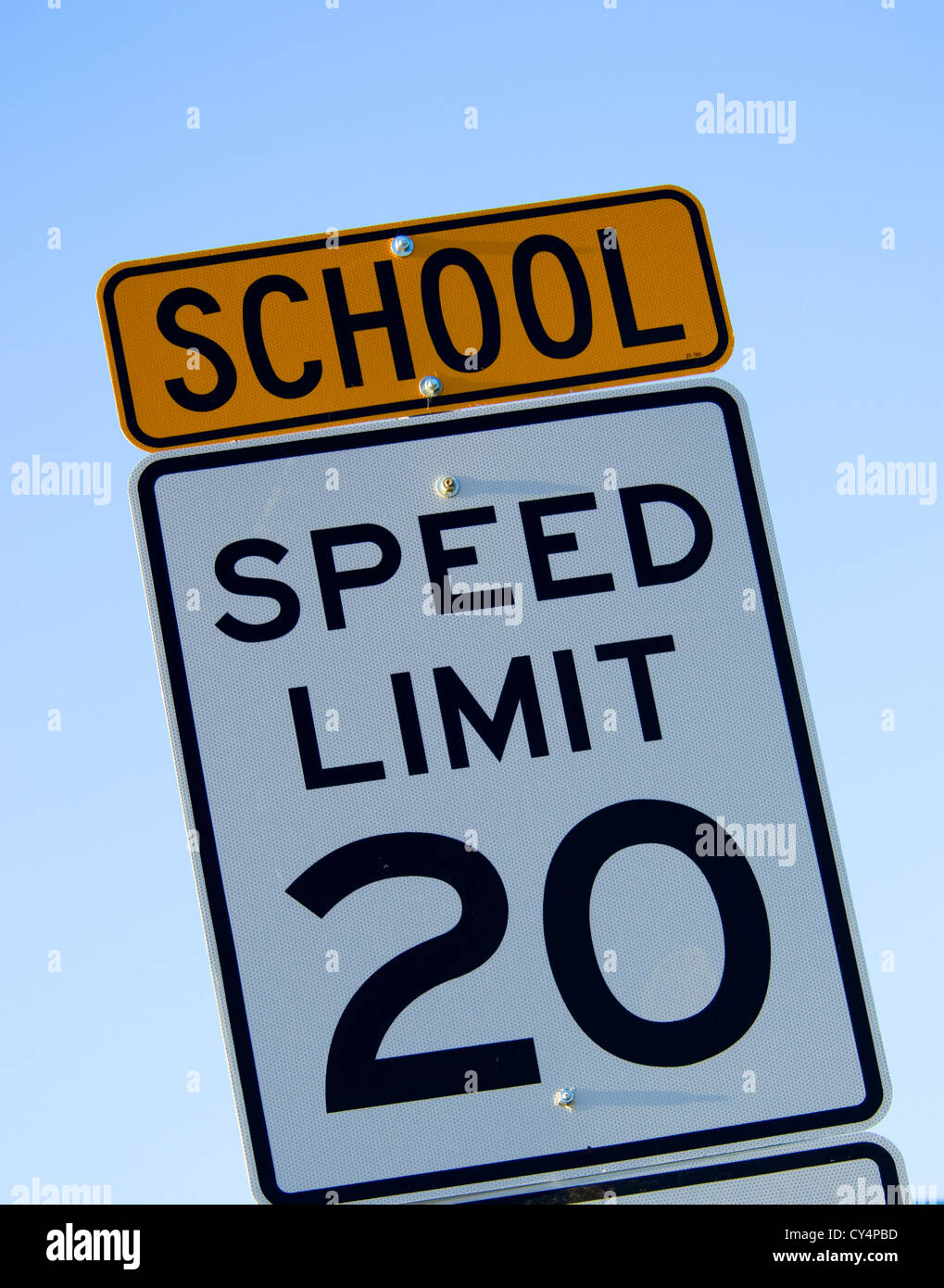 speed limit sign with special school warning in yellow against blue sky ...