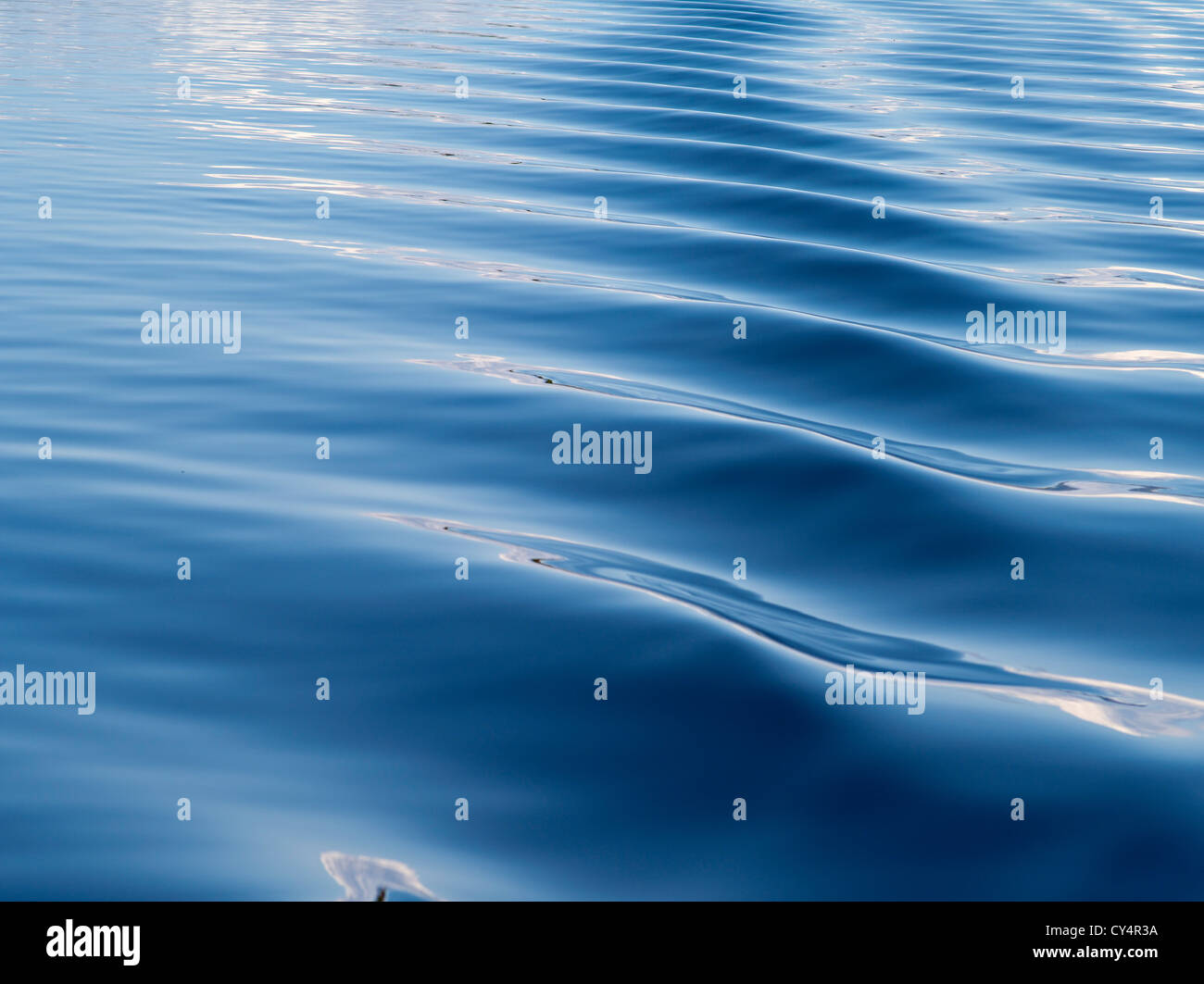 Waves raised by the wake of a boat in calm water at Kyle of Lochalsh ...