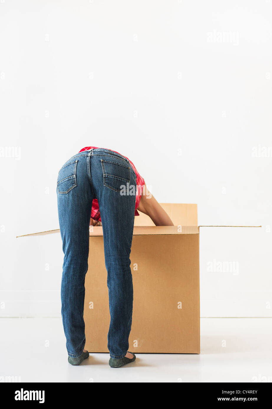 Studio shot of young woman looking into box Stock Photo - Alamy