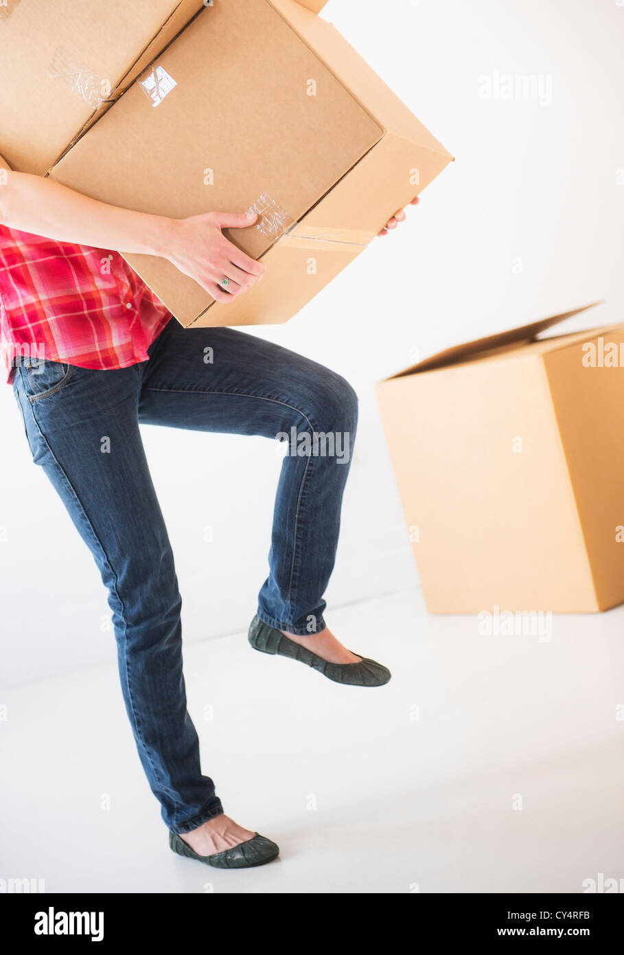 Studio shot of young woman carrying stack of boxes, low section Stock ...