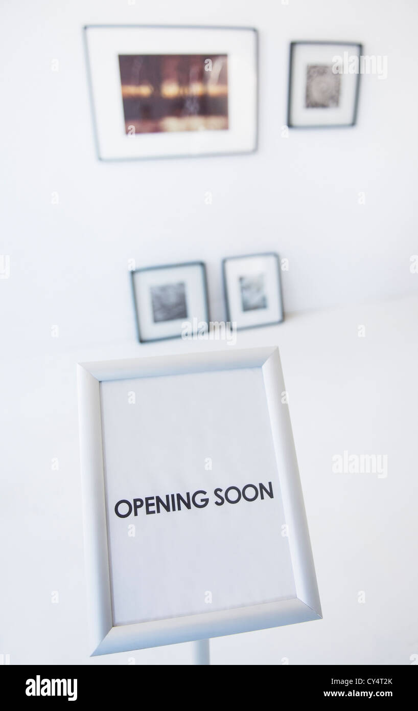 Opening sign with pictures on white wall in background Stock Photo - Alamy