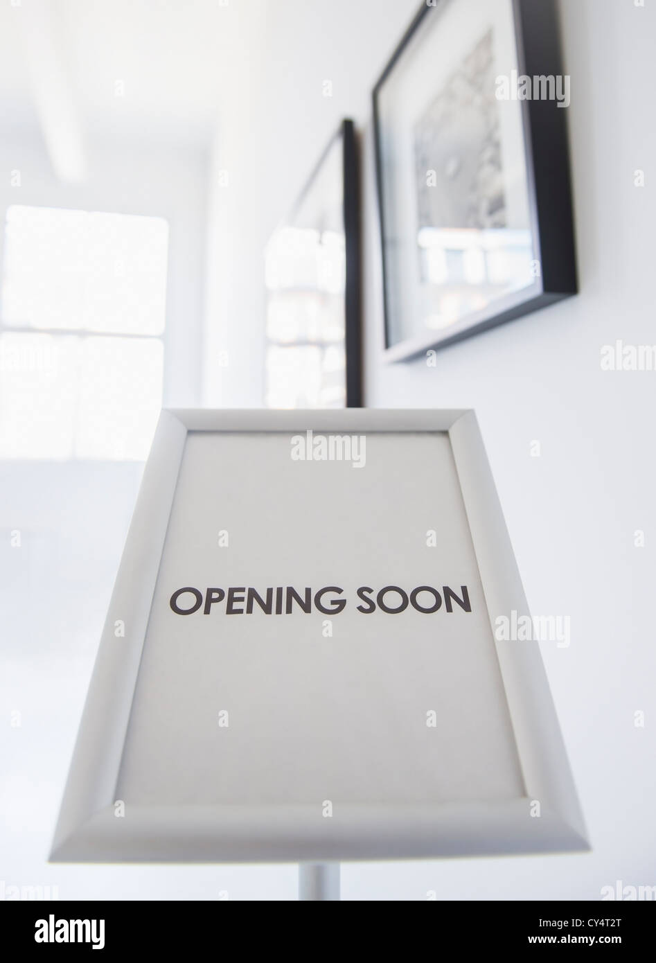 Opening sign with pictures on white wall in background Stock Photo - Alamy