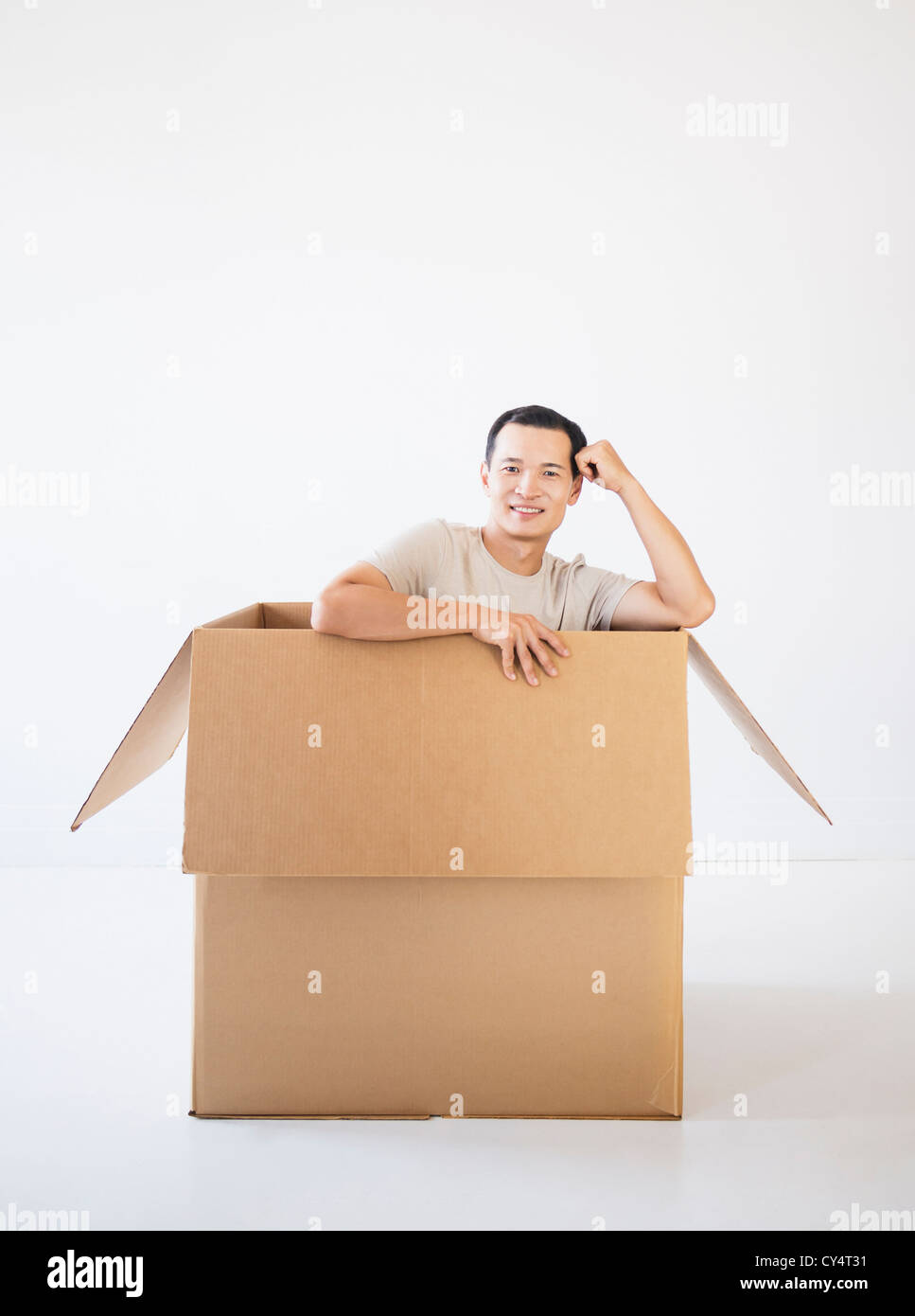 Man sitting in cardboard box Stock Photo - Alamy
