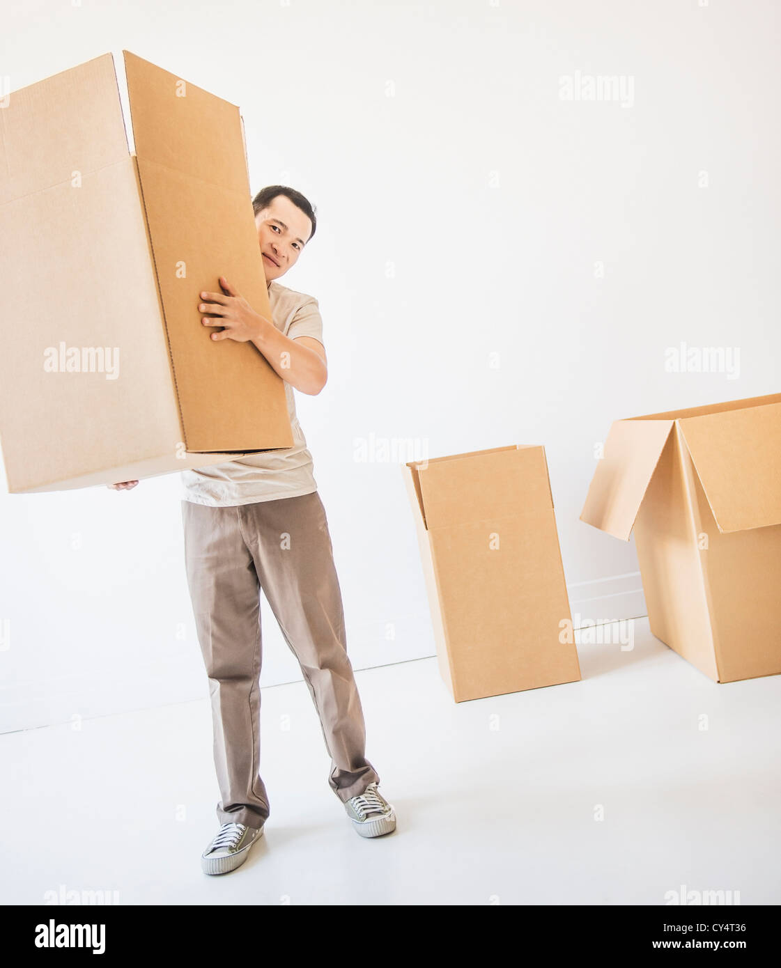 Mid adult moving cardboard boxes Stock Photo - Alamy