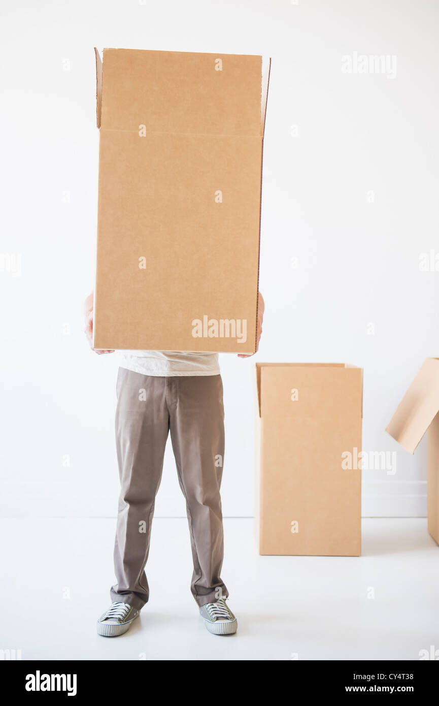 Mid adult man hiding inside of cardboard box Stock Photo - Alamy