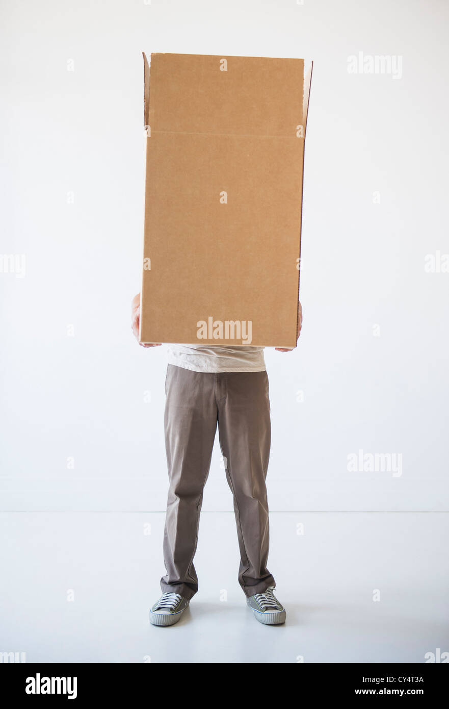 Mid adult man hiding inside of cardboard box Stock Photo - Alamy