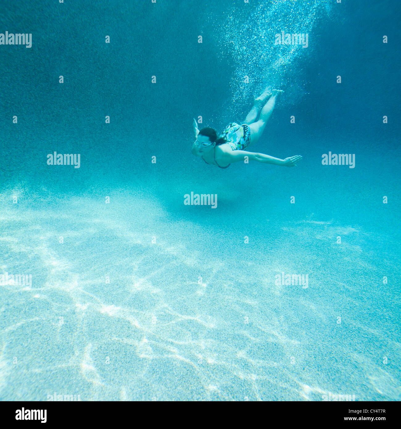 USA, Utah, St. George, Young attractive woman diving in swimming pool ...