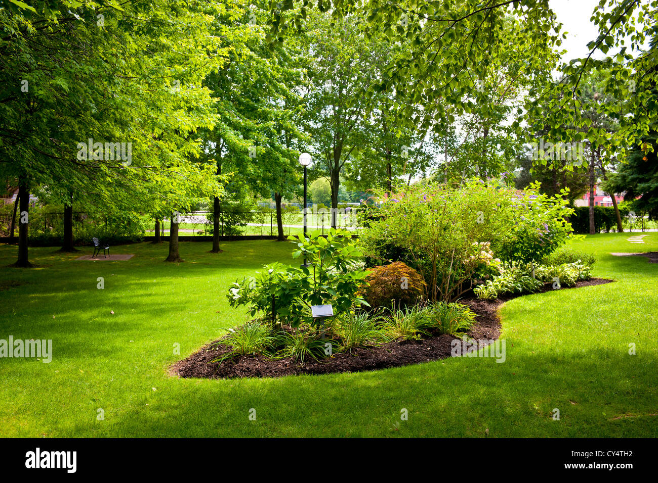 Lush landscaped grounds with garden in city park Stock Photo - Alamy