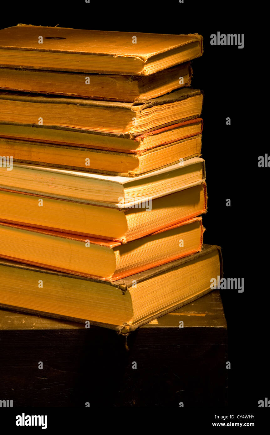 Vintage, antique stack of books painted with light against black ...