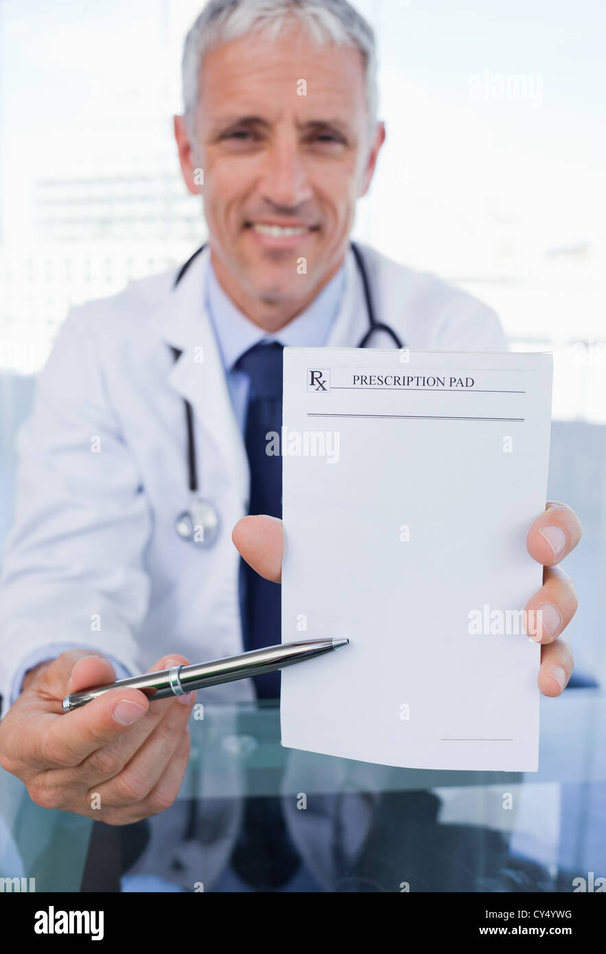 Portrait of a doctor showing a blank prescription sheet Stock Photo - Alamy