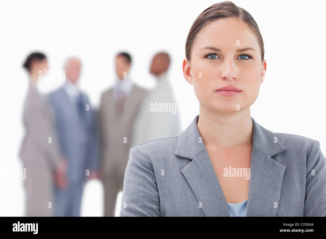 Serious businesswoman with co-workers behind her Stock Photo - Alamy