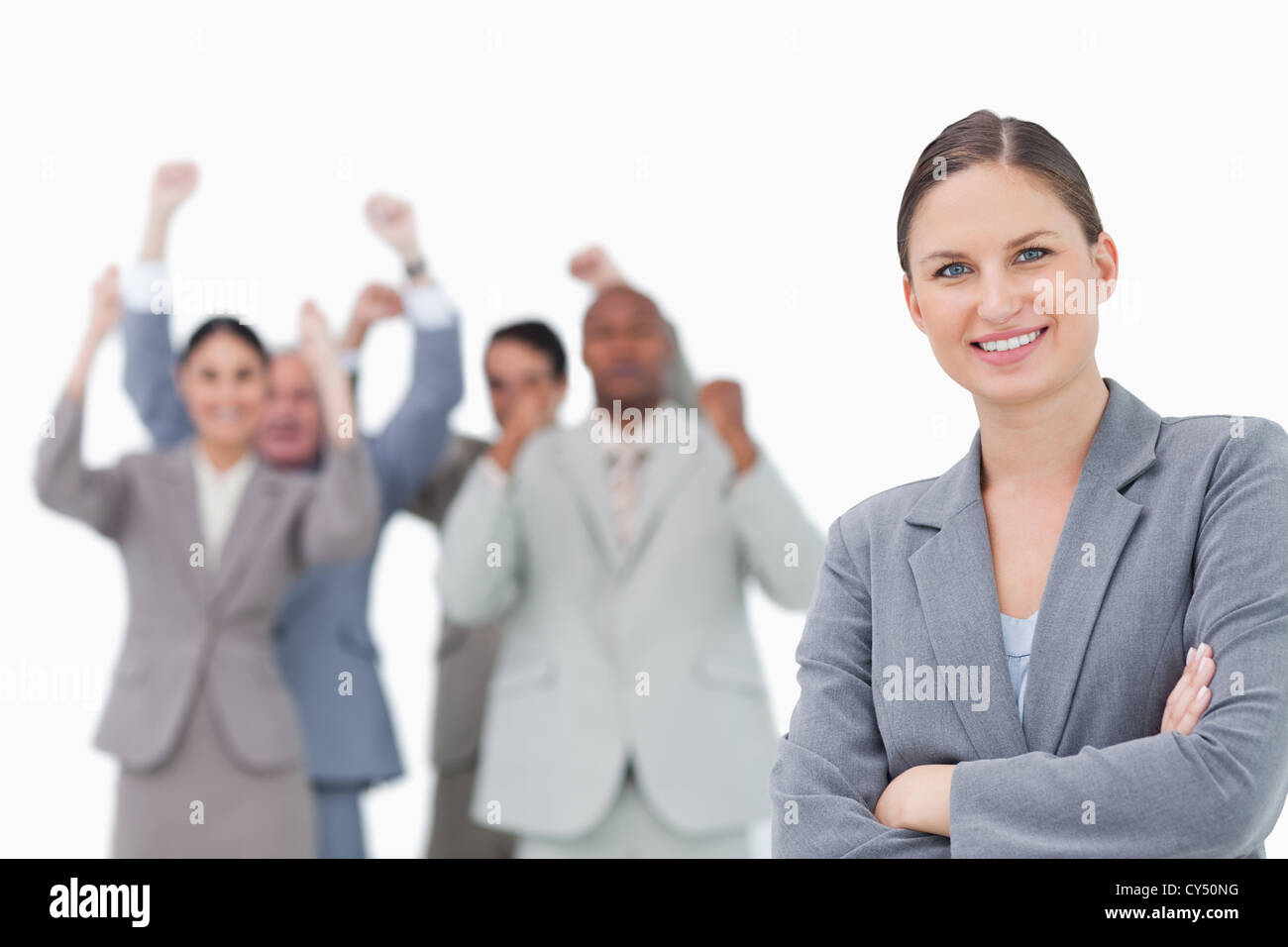 Smiling businesswoman with cheering team behind her Stock Photo - Alamy
