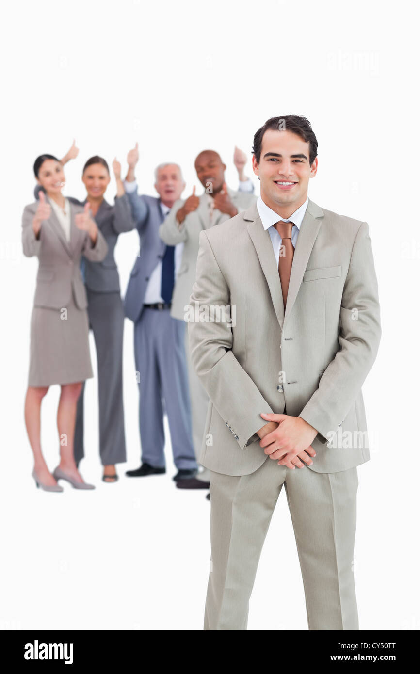 Smiling businessman with cheering team behind him Stock Photo - Alamy