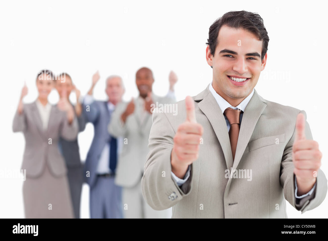 Salesman with team behind him giving thumbs up Stock Photo - Alamy