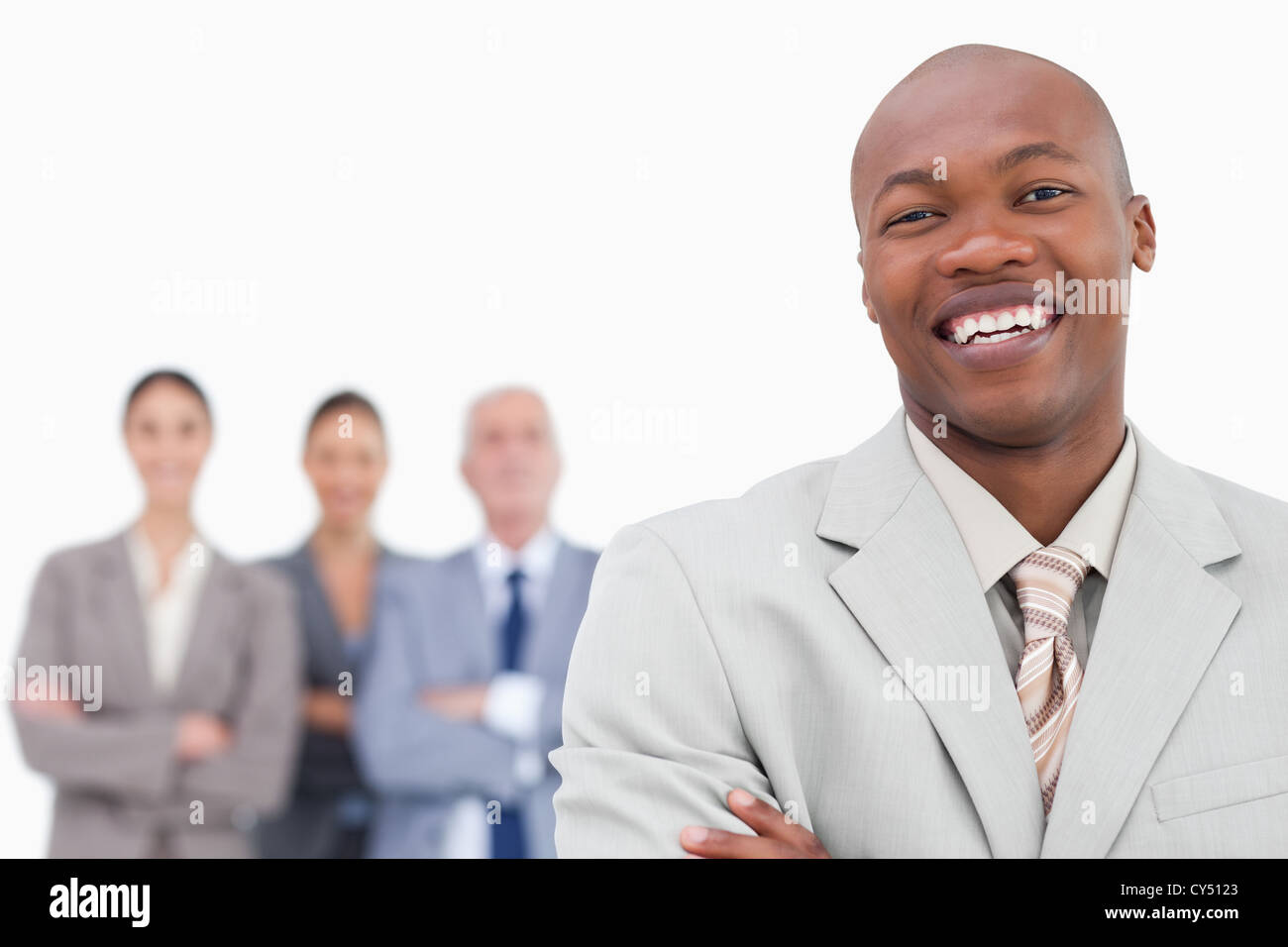 Smiling salesman with team behind him Stock Photo - Alamy