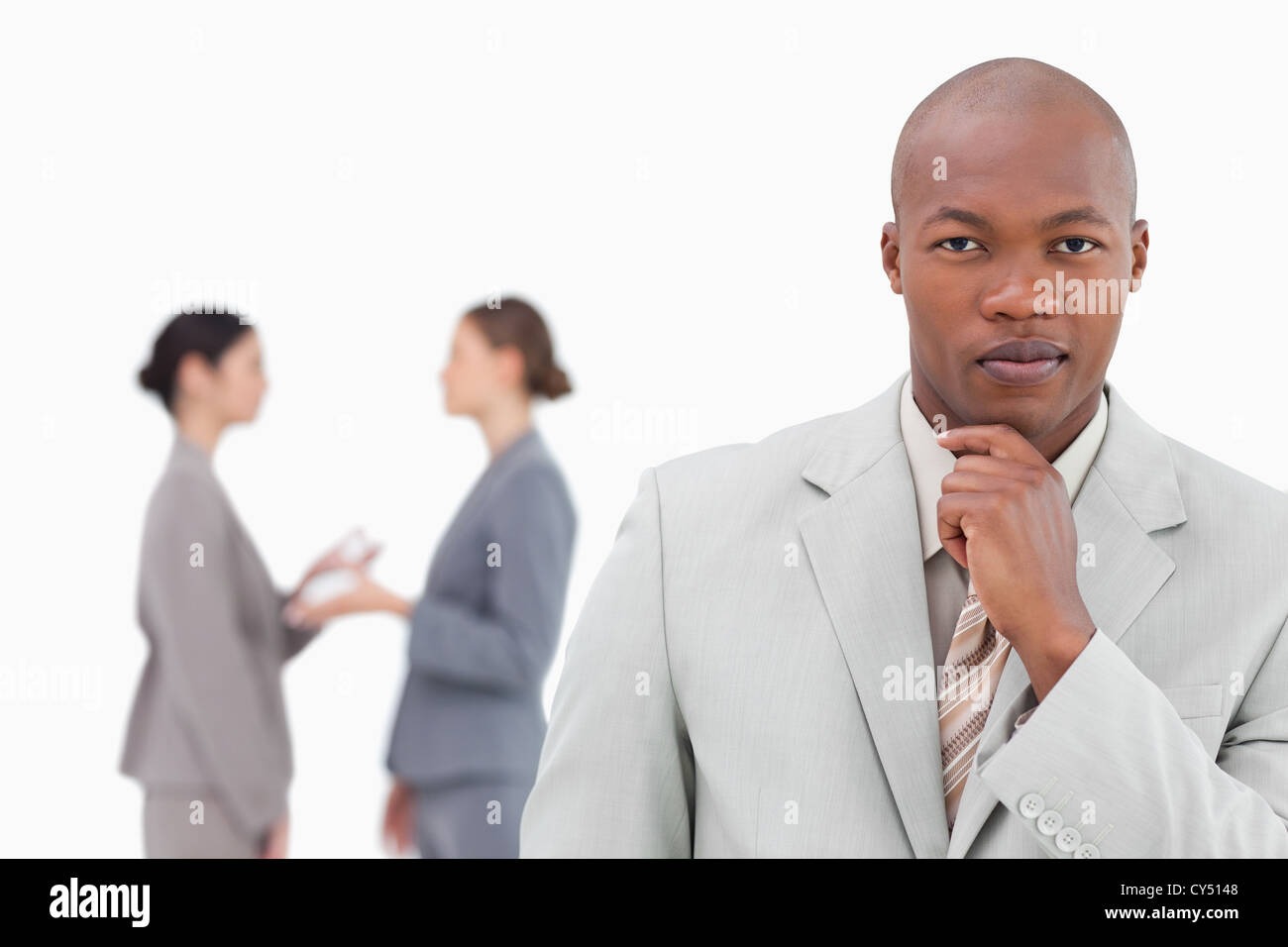 Thinking businessman with colleagues behind him Stock Photo - Alamy