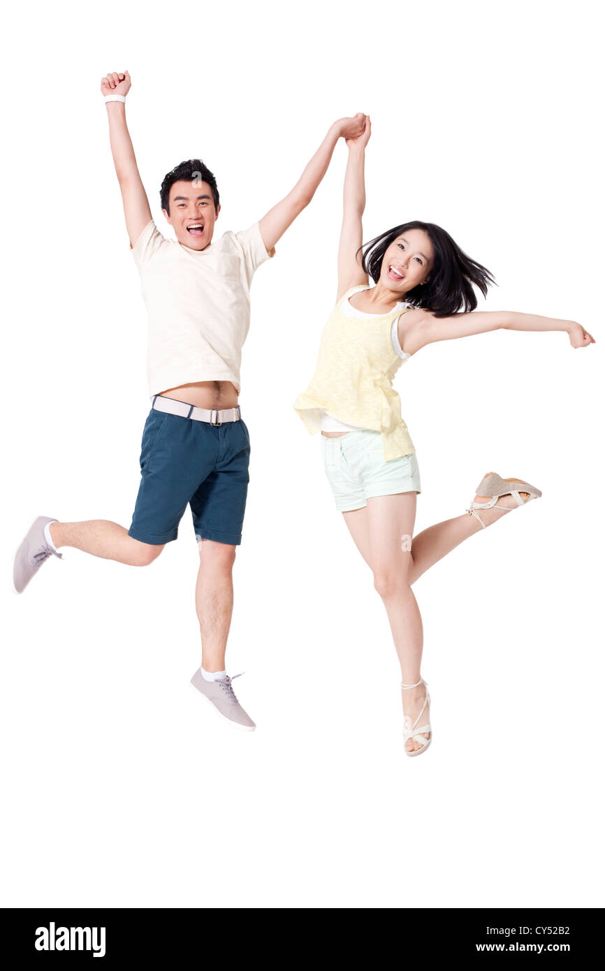 Portrait of cheerful young people jumping Stock Photo - Alamy
