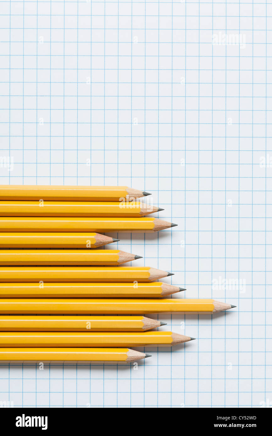 Grouping of yellow pencils in graph shape on graph paper Stock Photo ...