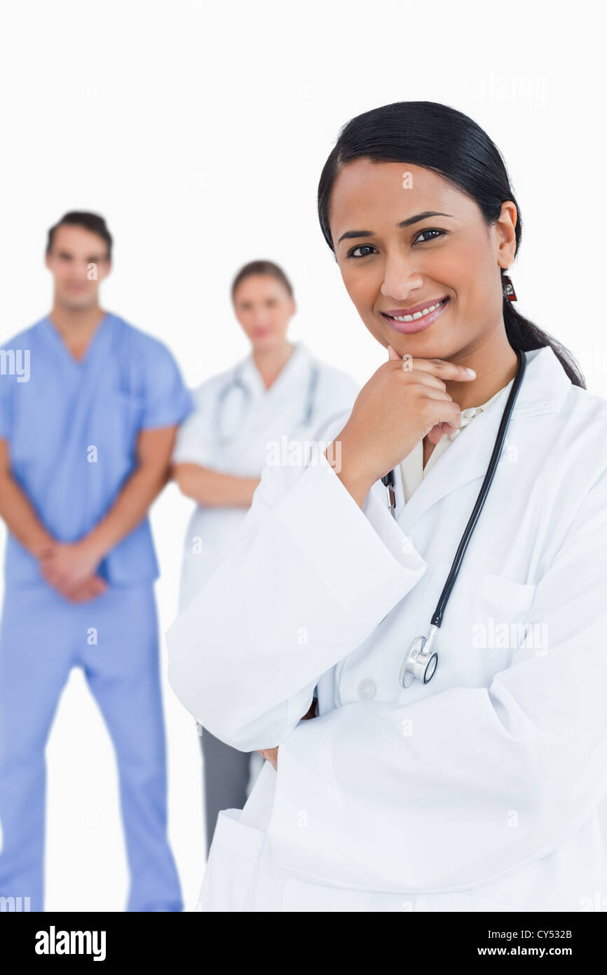 Smiling doctor with staff behind her Stock Photo - Alamy