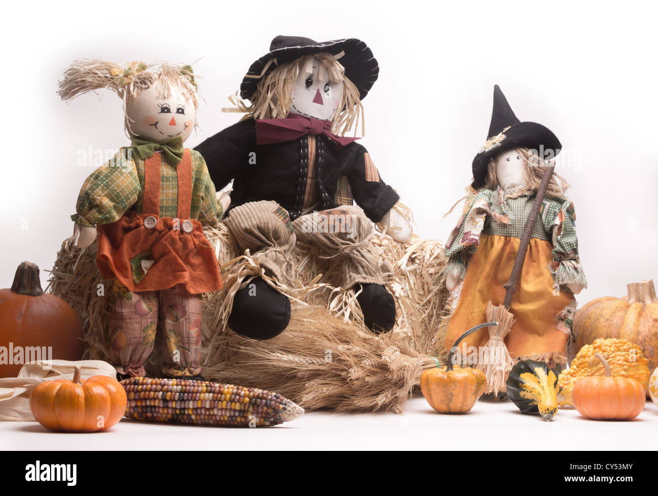 Scarecrow family on haystack with pumpkins, Indian corn, wheat stalks ...